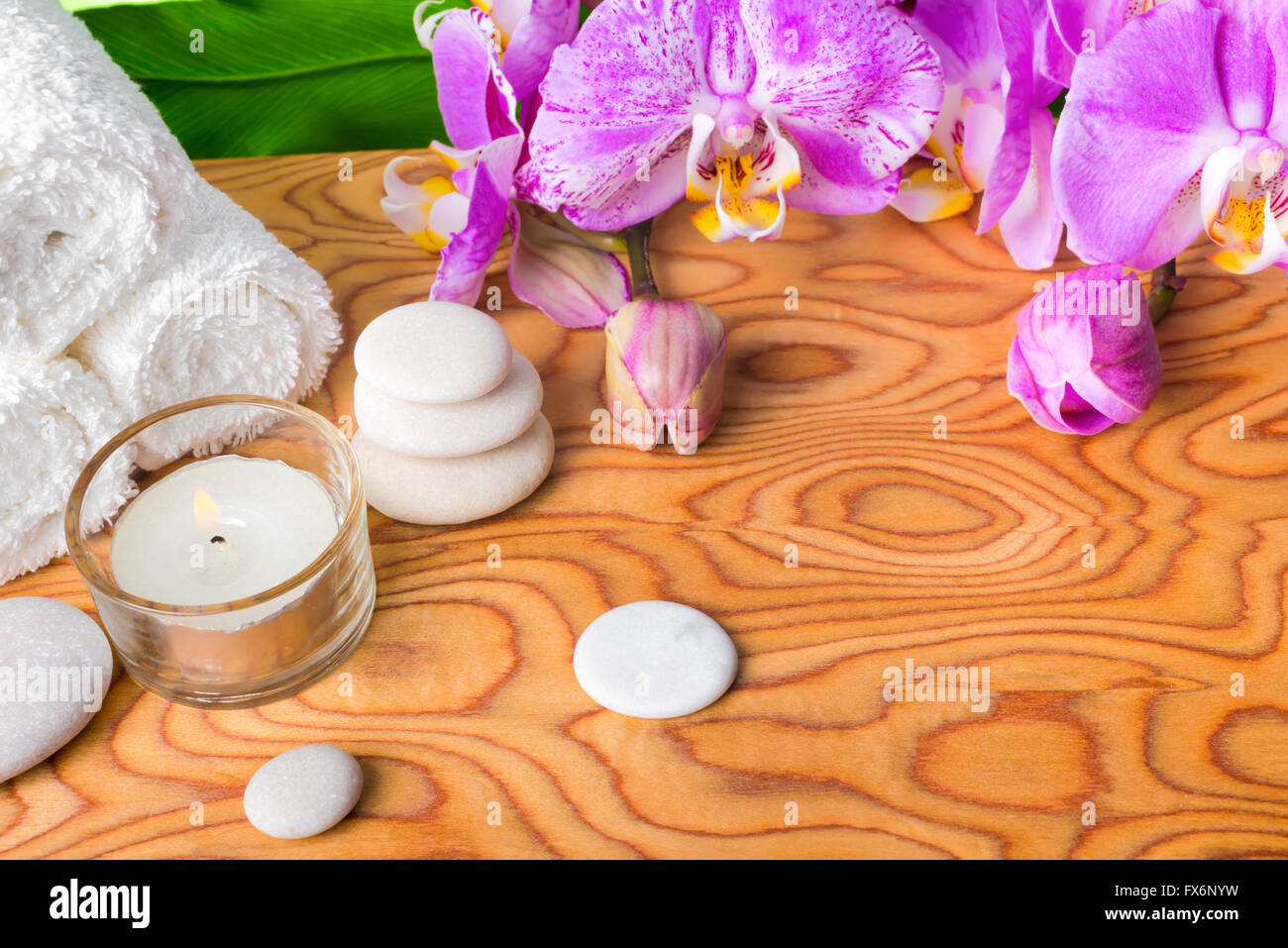 beautiful spa setting with blooming lilac orchid, white stones, towels ...