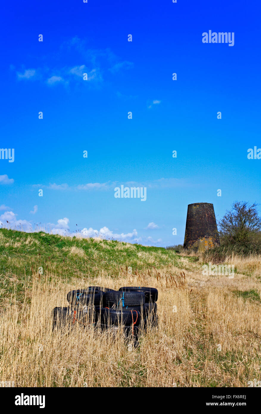A pile of old tyres with Old Hall Drainage Mill at Stokesby, Norfolk ...