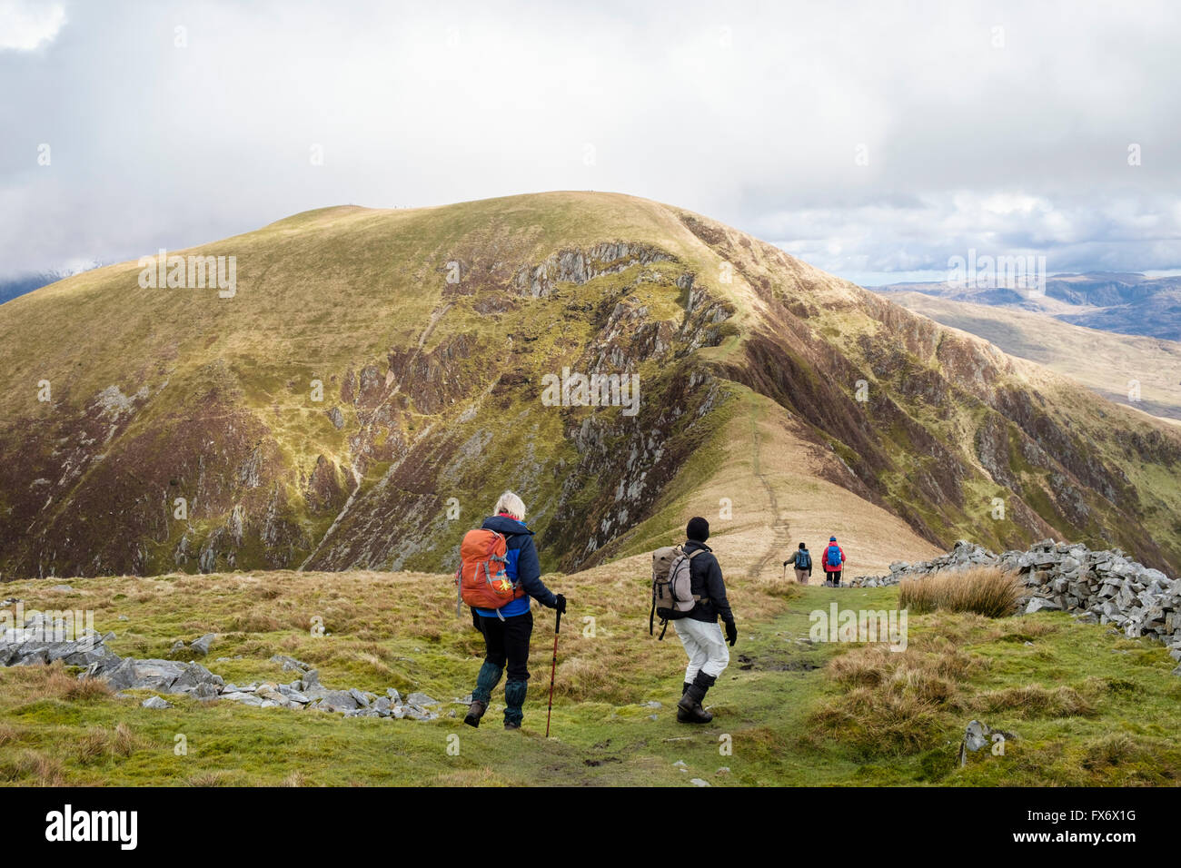 Hikers descending Mynydd Tal-y-mignedd towards col and Trum y Ddysgl on ...