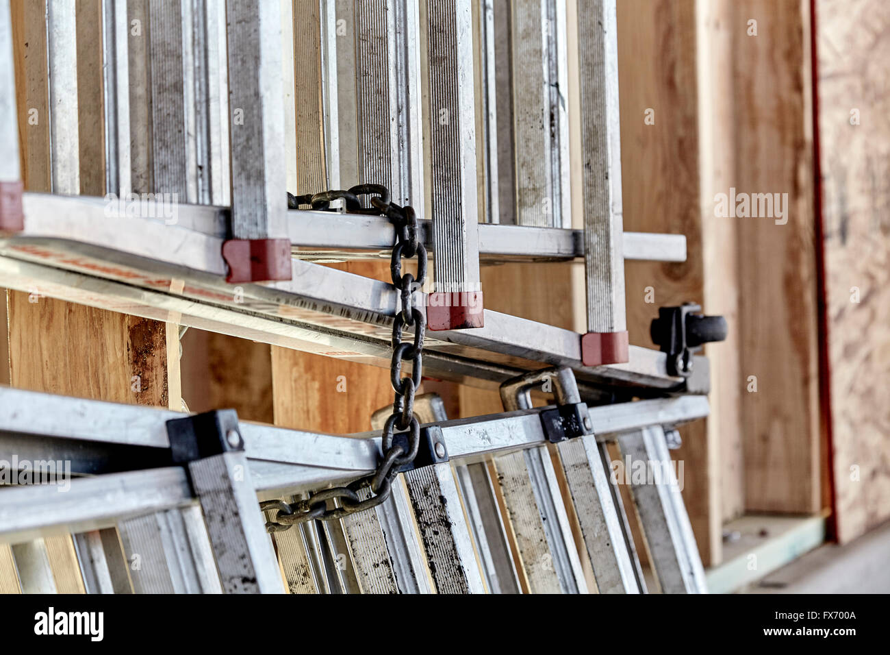 Construction ladders chained to wood framed wall of new construction ...