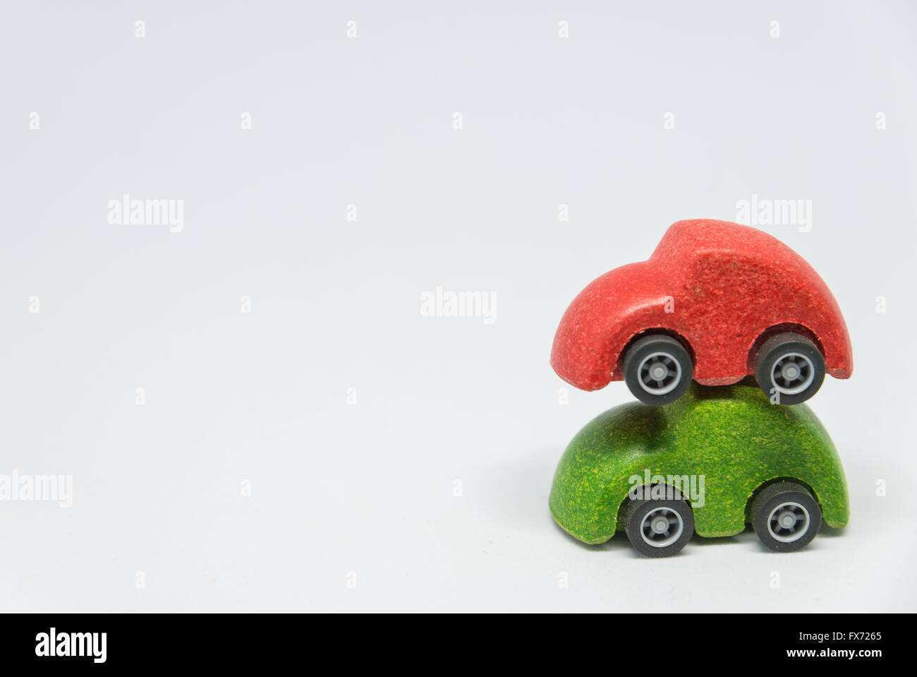Red toy car overlay on green toy car with white background and ...