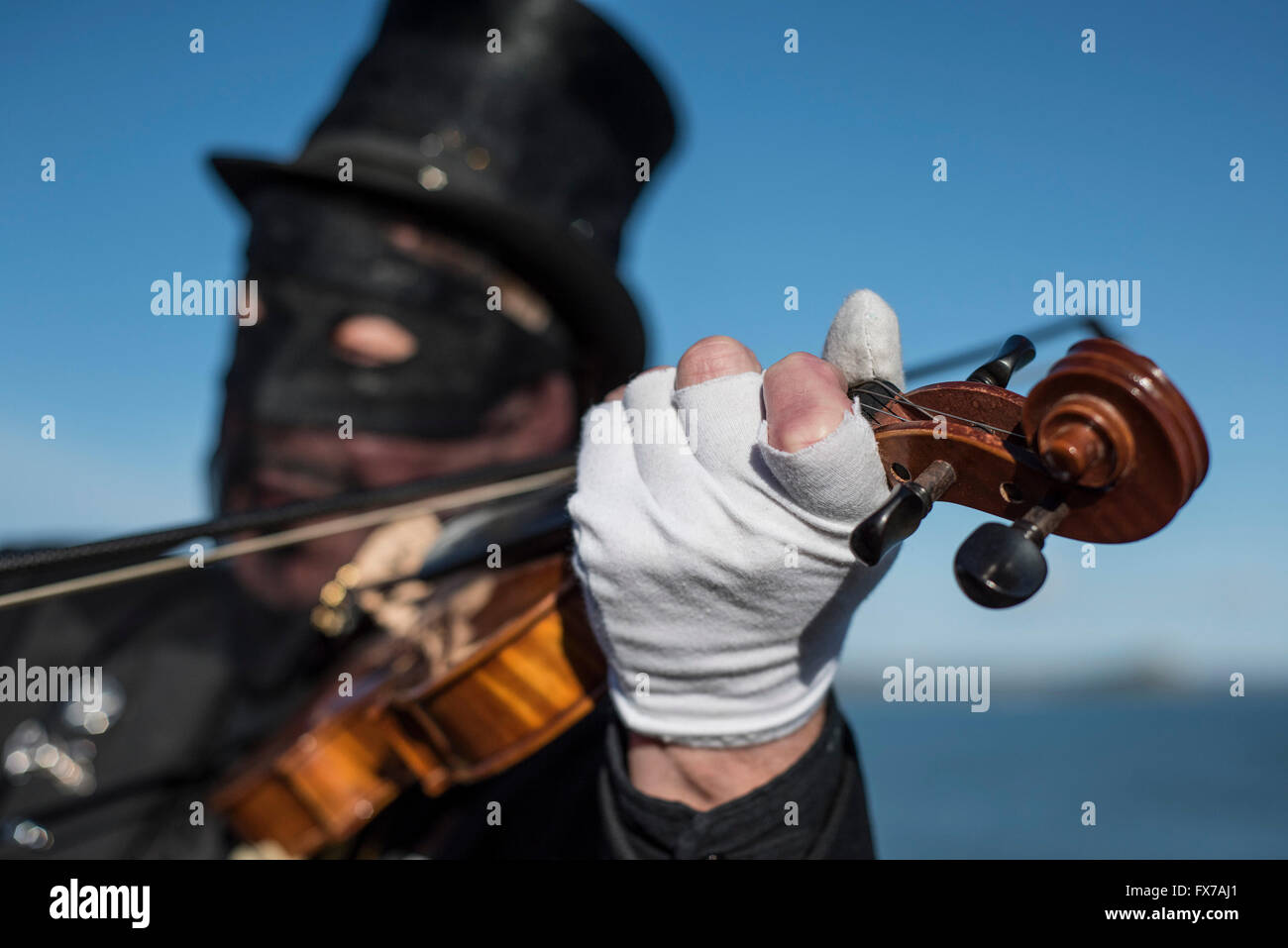 A masked guiser plays the violin Stock Photo - Alamy