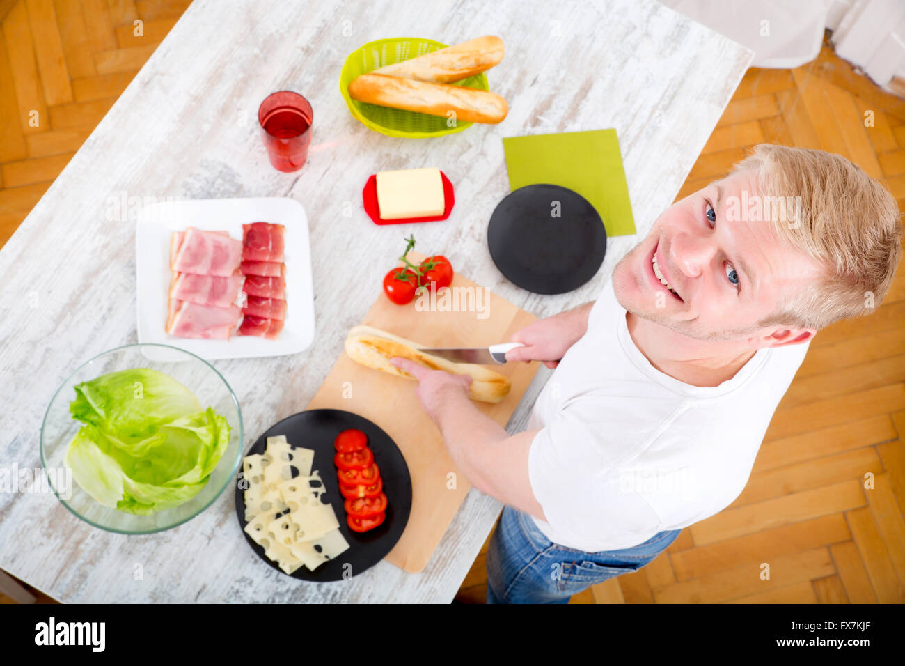 A young man preparing a sandwich in the kitchen Stock Photo - Alamy