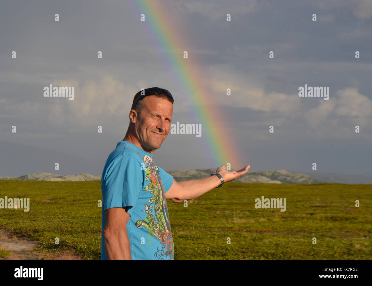 A man is standing at end of the rainbow Stock Photo - Alamy