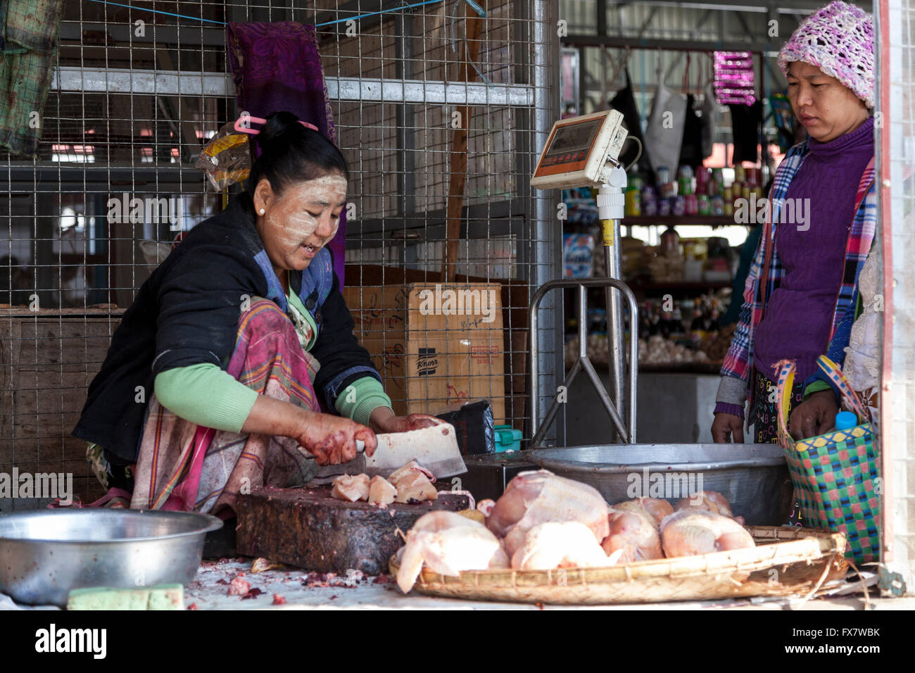 A woman butcher carving the fresh meat on the bare ground, at the New ...