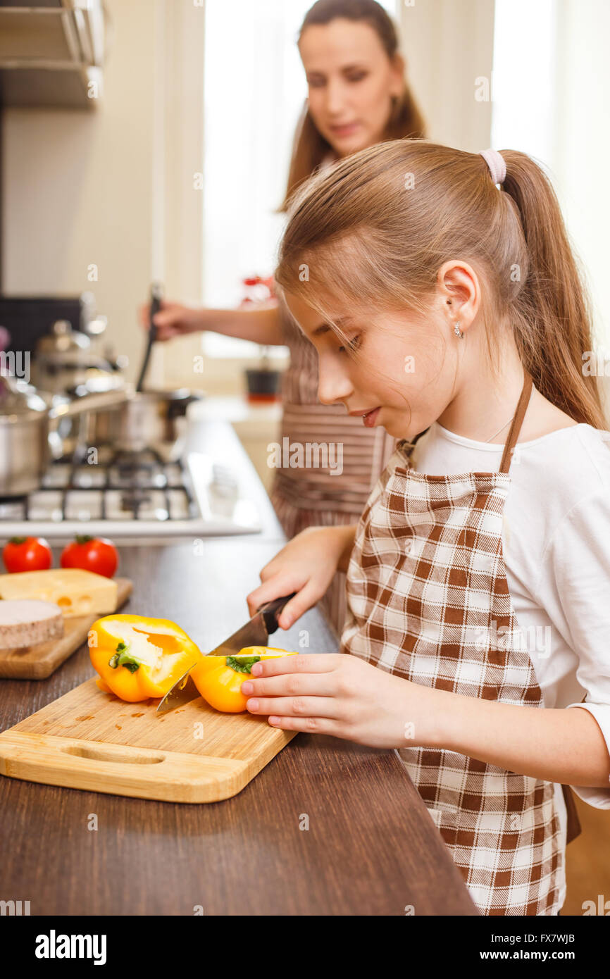 Family cooking background. Small girl preparing salad at the kitchen ...