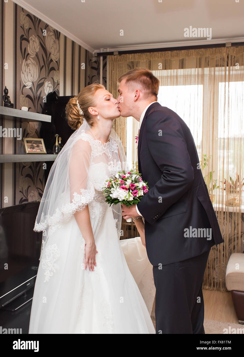 Kiss the bride and groom Stock Photo - Alamy