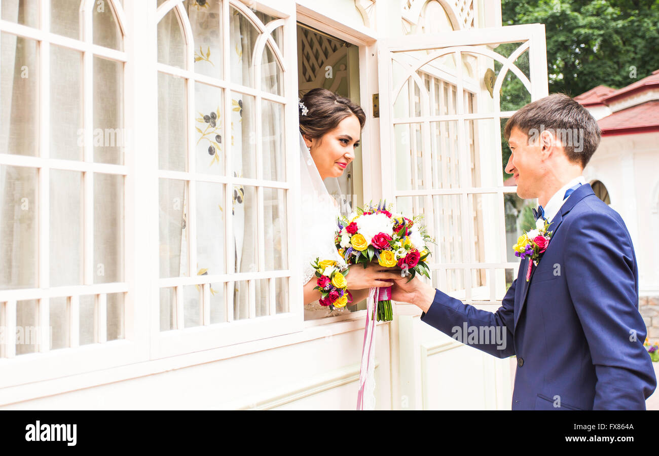 Handsome groom giving hand to beautiful bride Stock Photo - Alamy