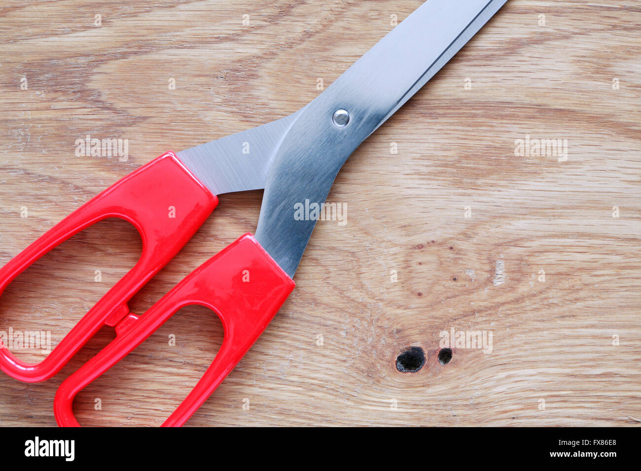 Scissors with red handles on nice wooden board Stock Photo - Alamy