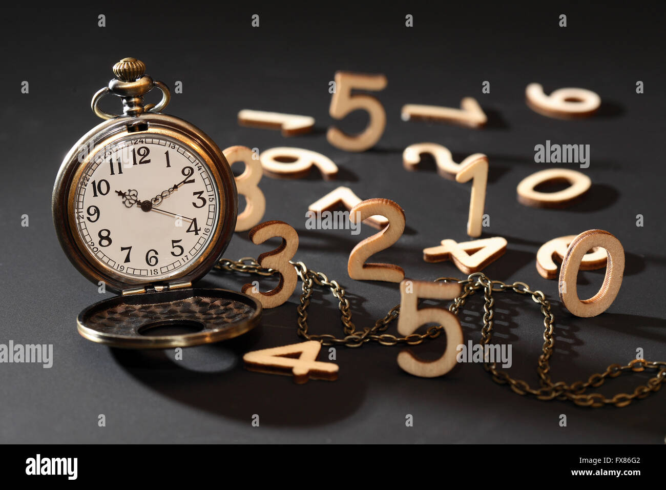 Vintage pocket watch and lot of wooden digits on dark background Stock ...