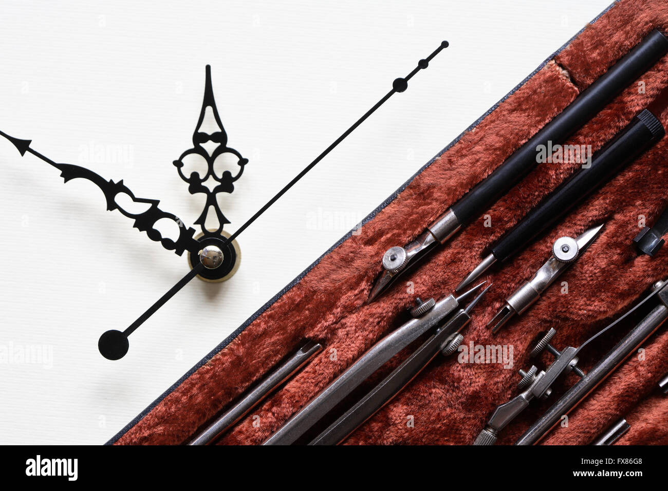 Set of drawing instrument in box near clock Stock Photo - Alamy