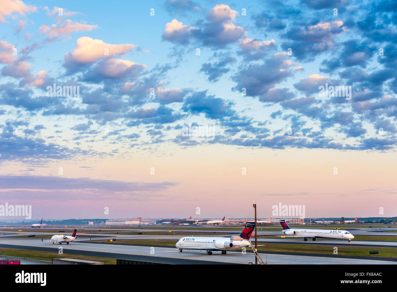 Delta Air Lines jets taxiing under a dramatic sunset sky at Hartsfield ...