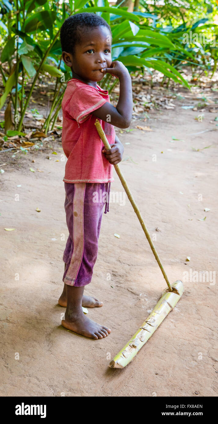 Boy with a simple makeshift wooden toy propelled using a stick ...