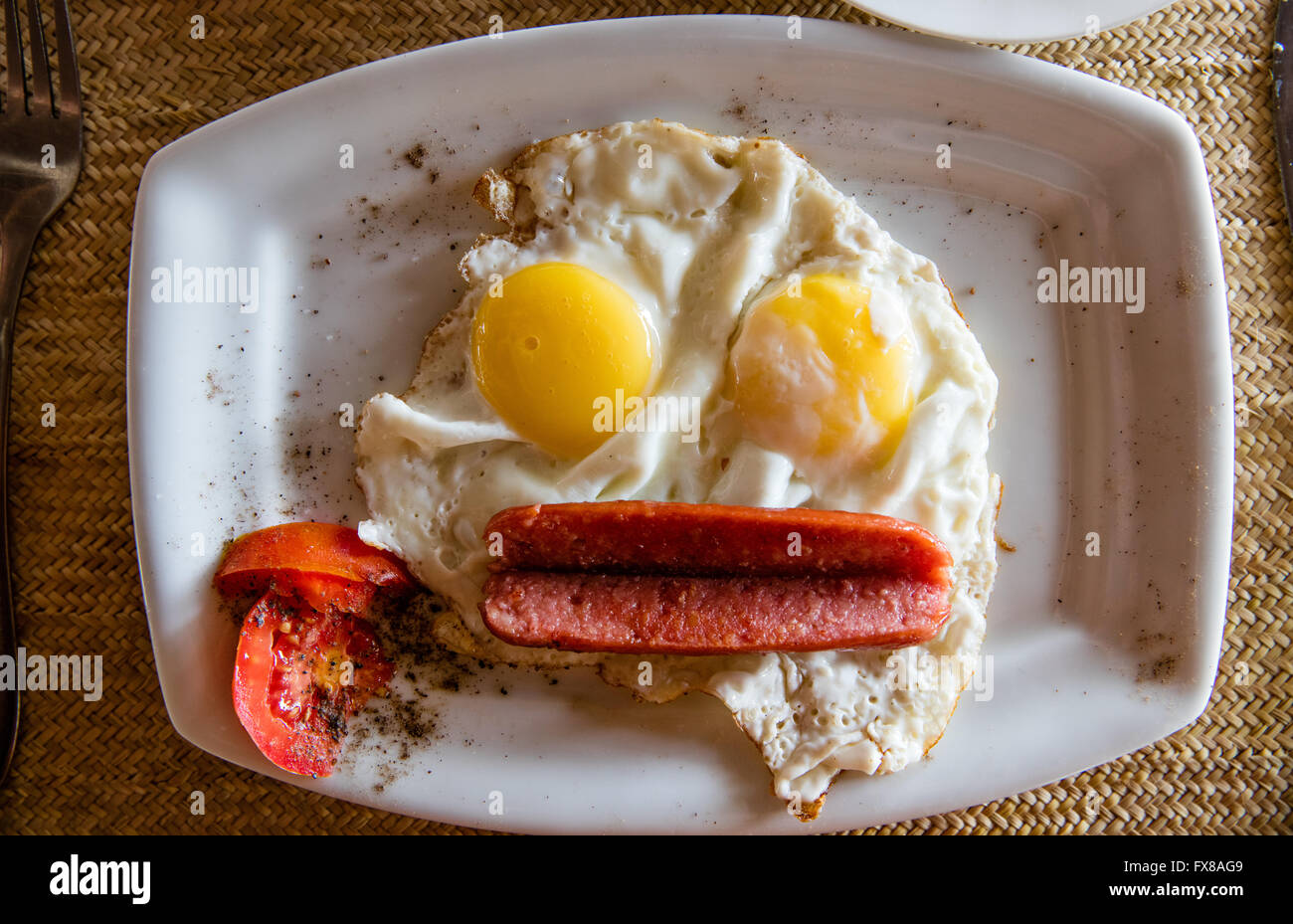 Smiley face breakfast of sunny side eggs and a split sausage with ...