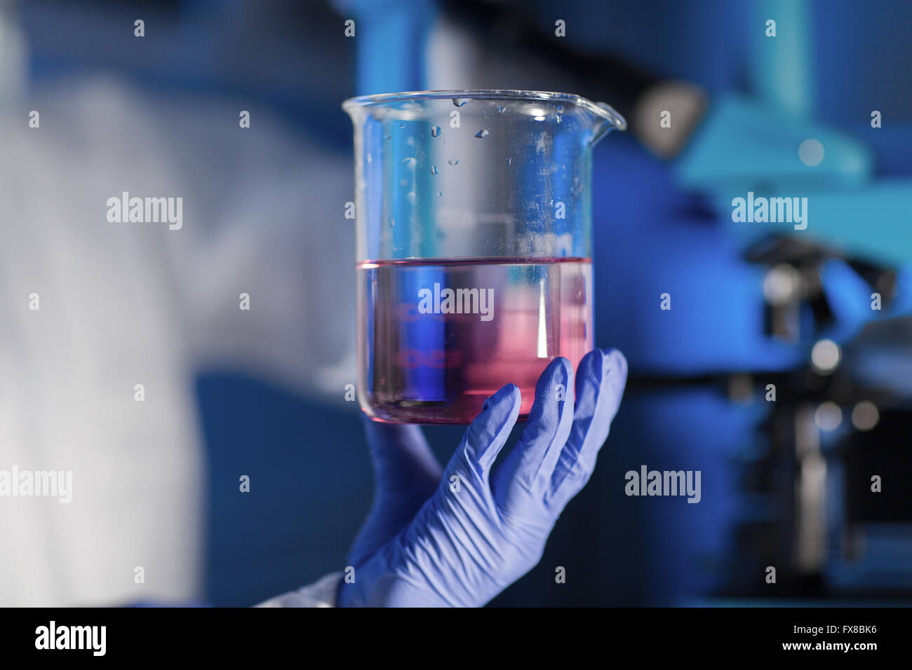close up of hand holding glass in chemical lab Stock Photo - Alamy