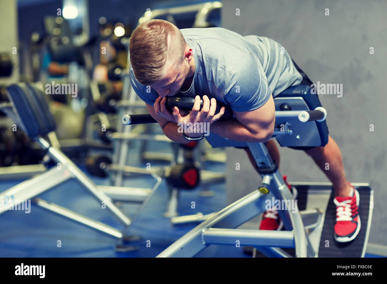 young man flexing back muscles on bench in gym Stock Photo - Alamy