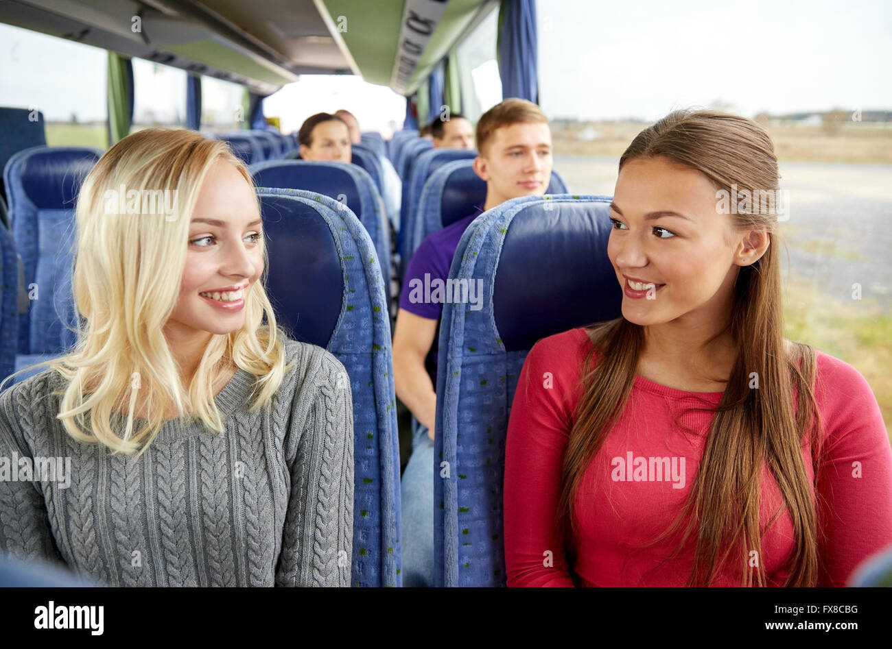 happy young women talking in travel bus Stock Photo - Alamy