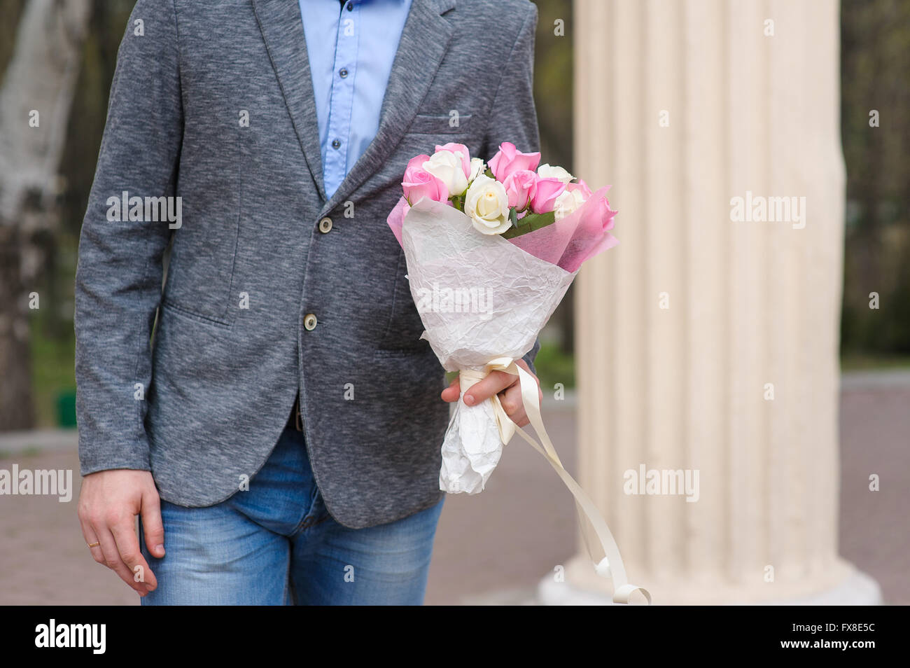 Handsome with bouquet of roses man waiting a woman. bouquet of white ...