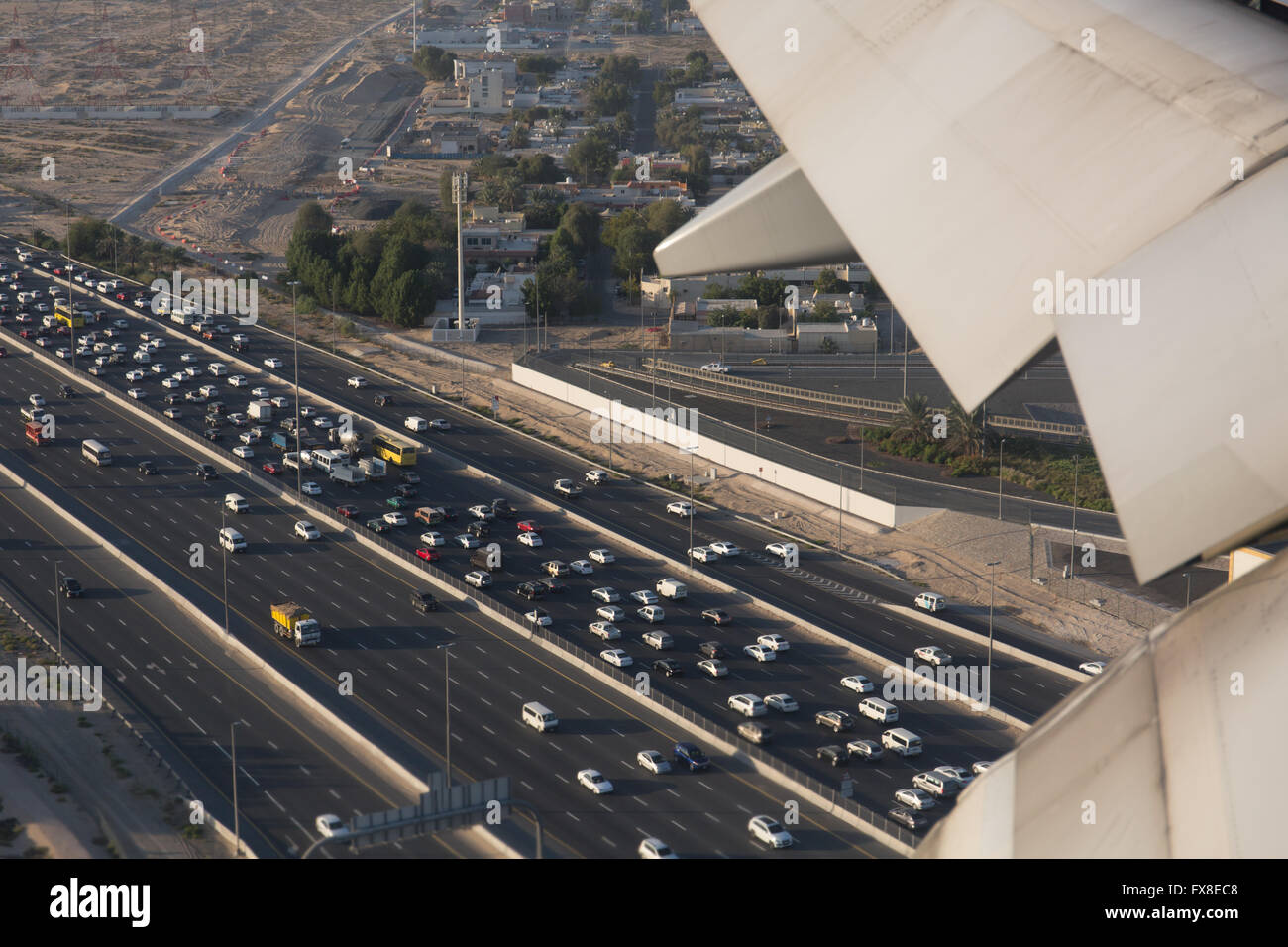 Plane flying above Dubai motorway Stock Photo - Alamy
