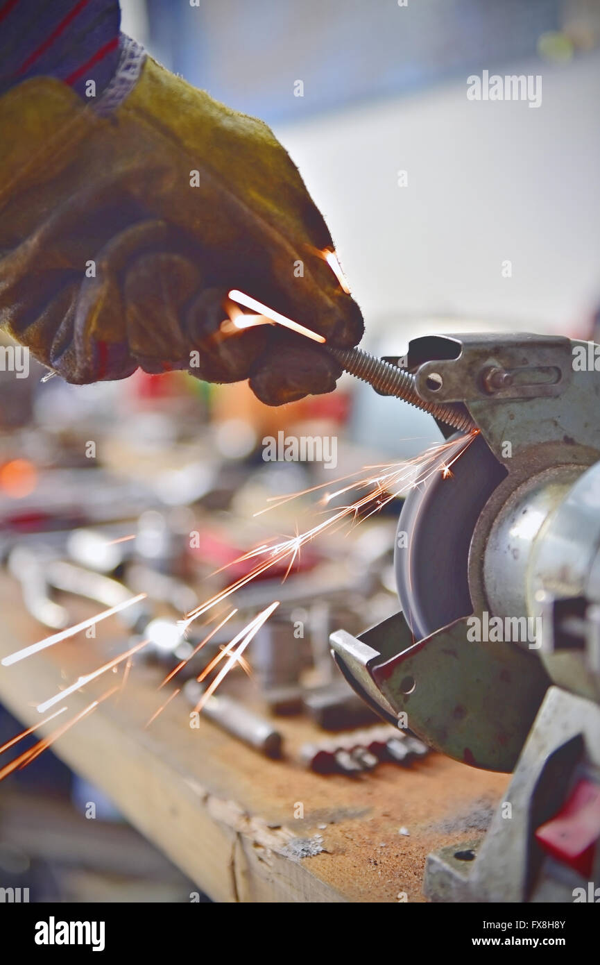 Vintage photo with mechanic polishing a screw on industrial polishing ...