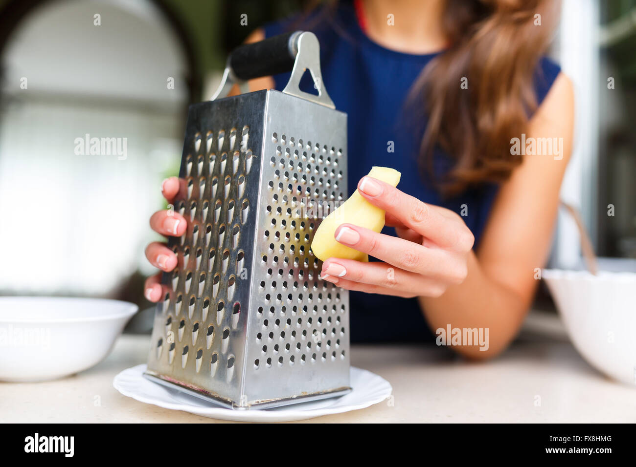 Young woman grating ginger in the kitchen Stock Photo - Alamy