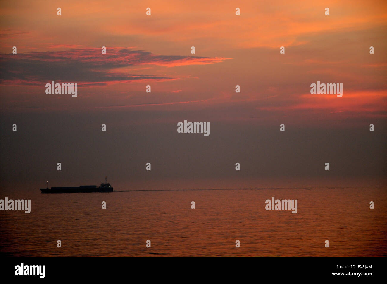 Cargo ship at sea, late evening sunset Stock Photo - Alamy