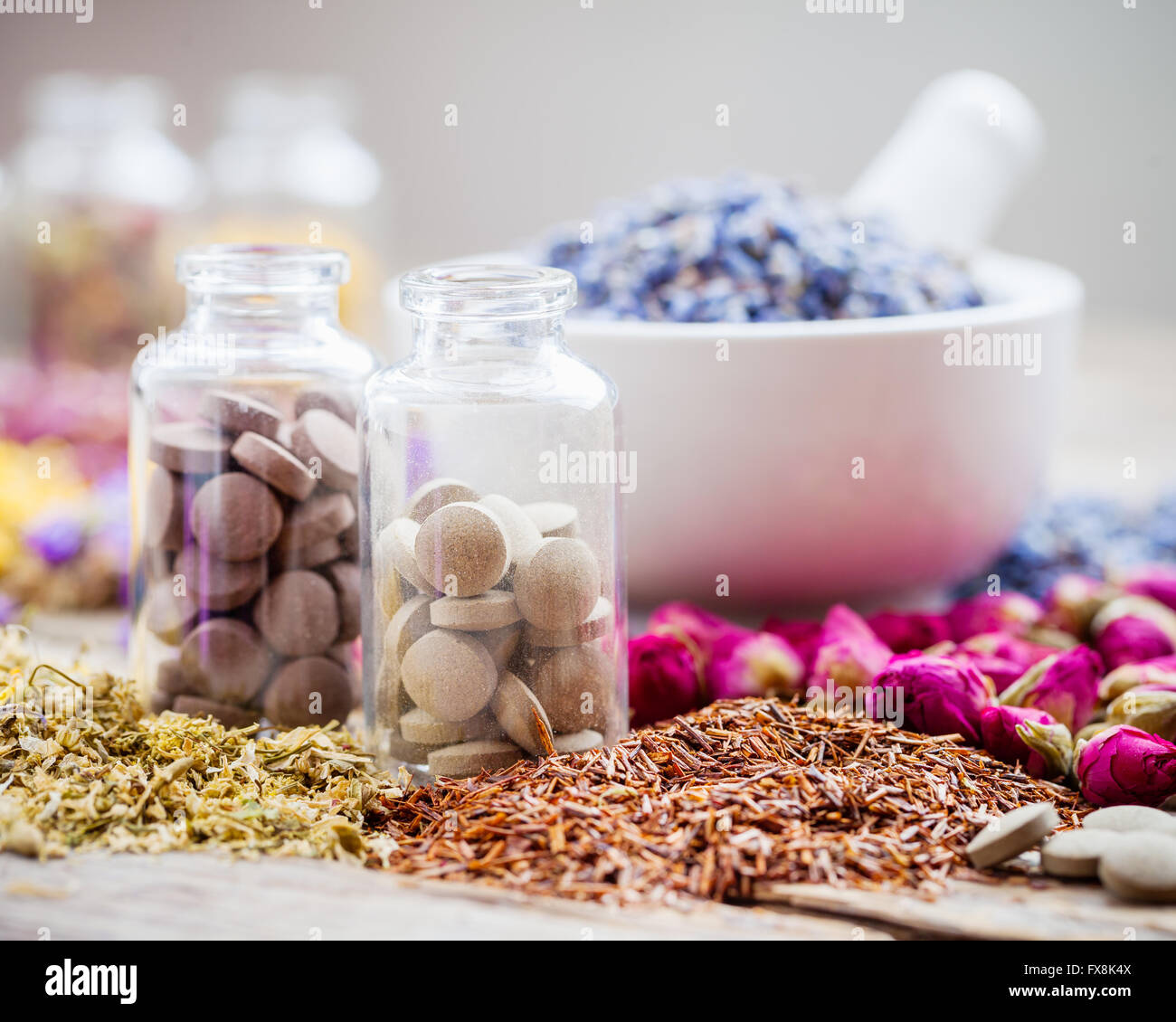 Bottles of natural tablets, healing herbs and mortar with dry lavender ...