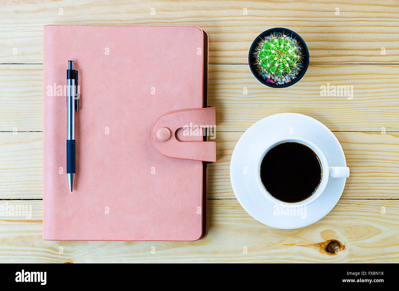 Leather notebook with pen and cup of coffee on wooden table.Top view ...