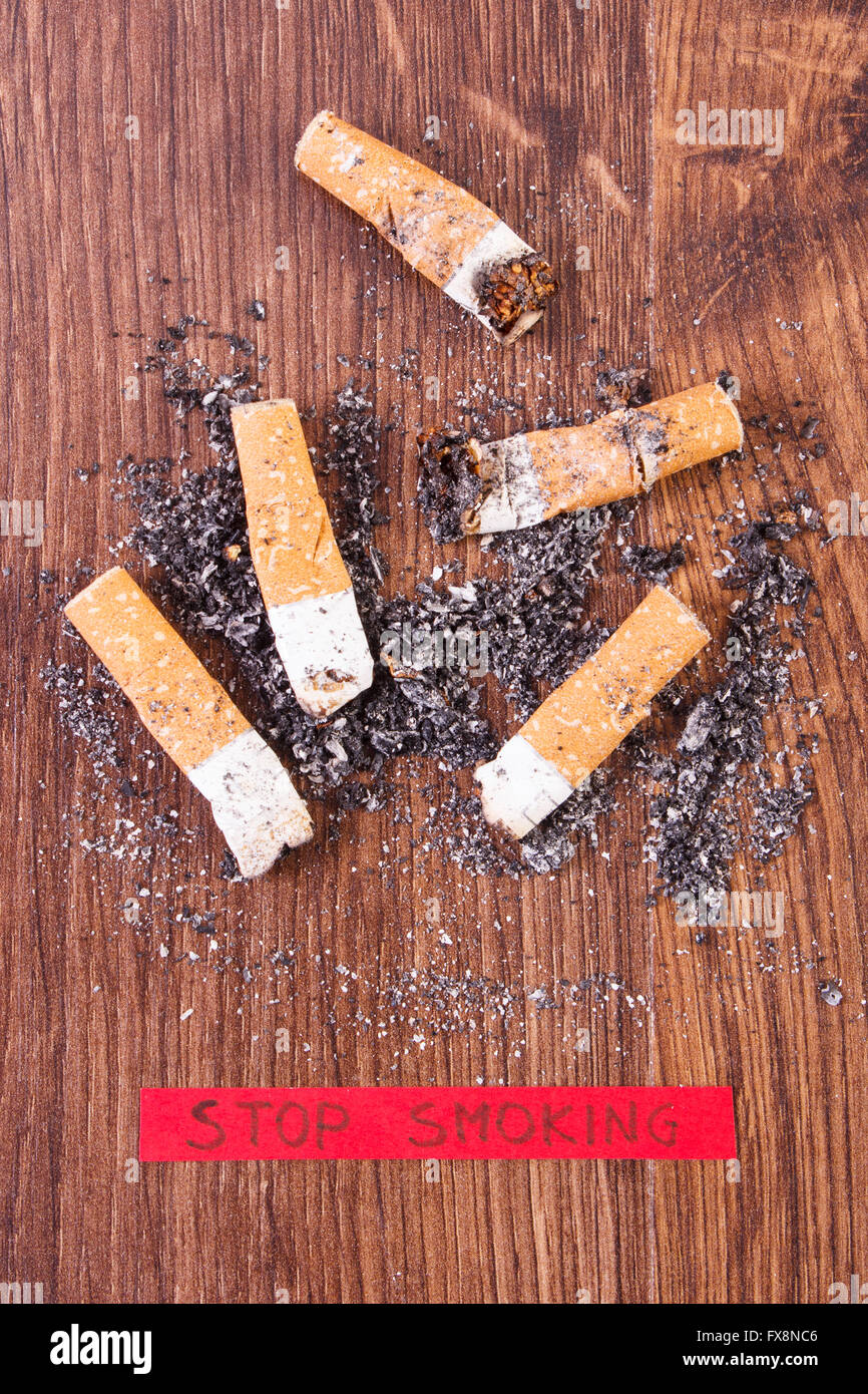 Cigarette butts and ash with inscription stop smoking, concept of ...