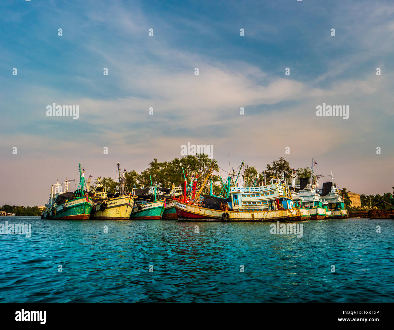 Group of colorful fishing boats at sunset Stock Photo - Alamy