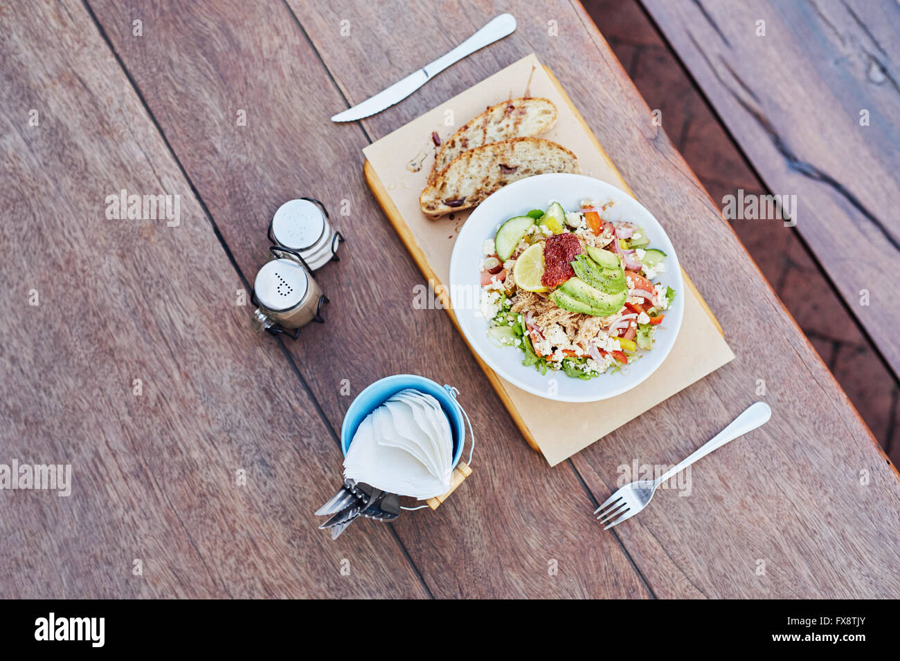 Simple table setting with salad, cutlery, condiments and serviet Stock ...