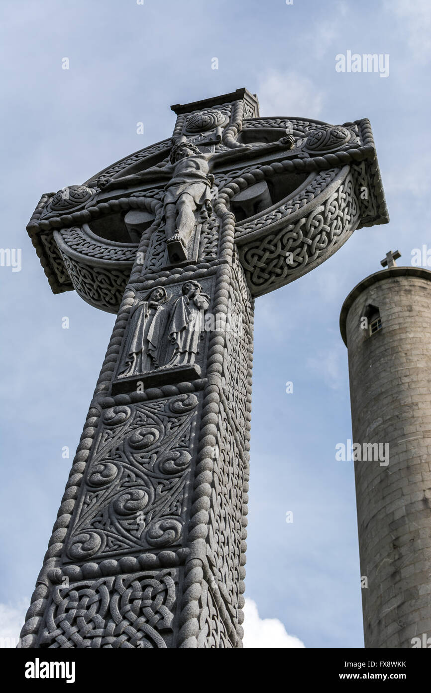 A stone Celtic Cross stands in front of Daniel O'Connell tower in ...