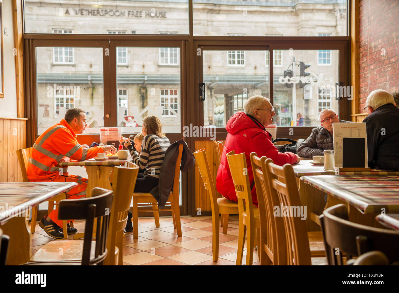 People sitting at tables in the Express Cafe , a small independently ...