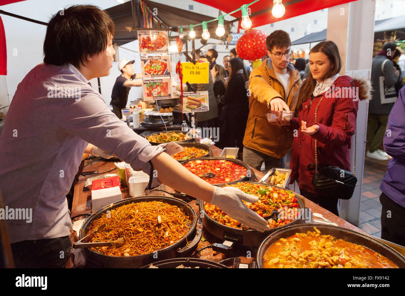 London market; People buying food at a chinese street food stall ...