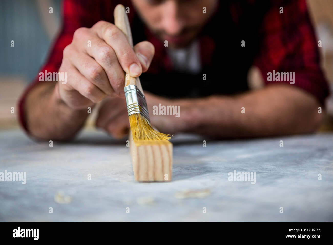Carpenter painting a piece of wood Stock Photo - Alamy