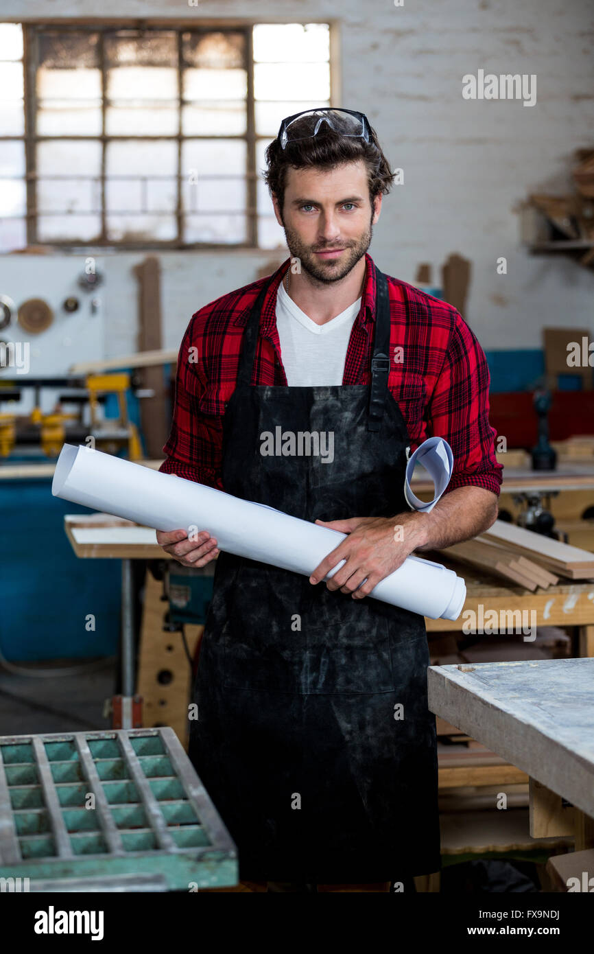 Carpenter with plans smiling Stock Photo - Alamy