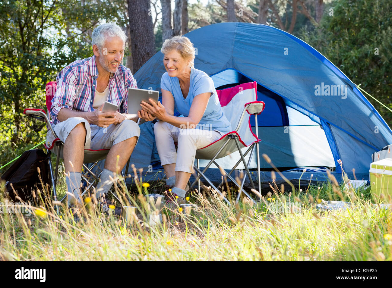 Senior couple relaxing beside their tent Stock Photo - Alamy