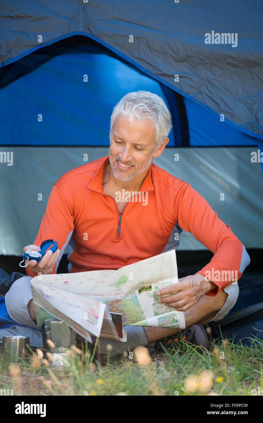 Mature man looking a map and holding a compass Stock Photo - Alamy