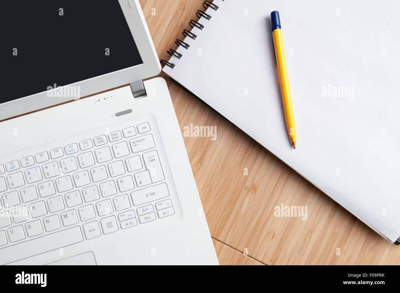 Laptop and notepad on the table with blank screen and pages Stock Photo ...