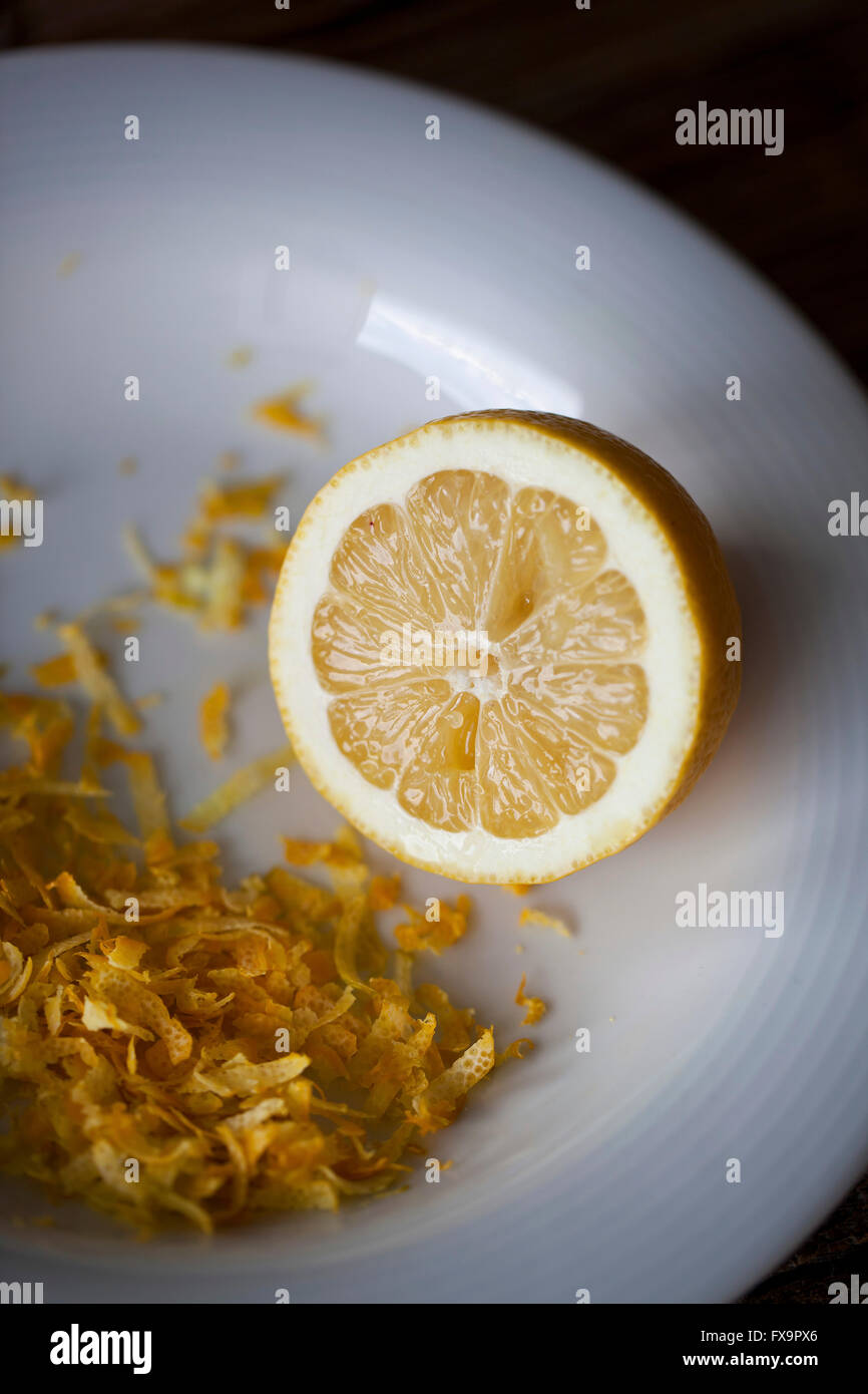 Half of lemon and grated lemon zest on a white plate Stock Photo - Alamy