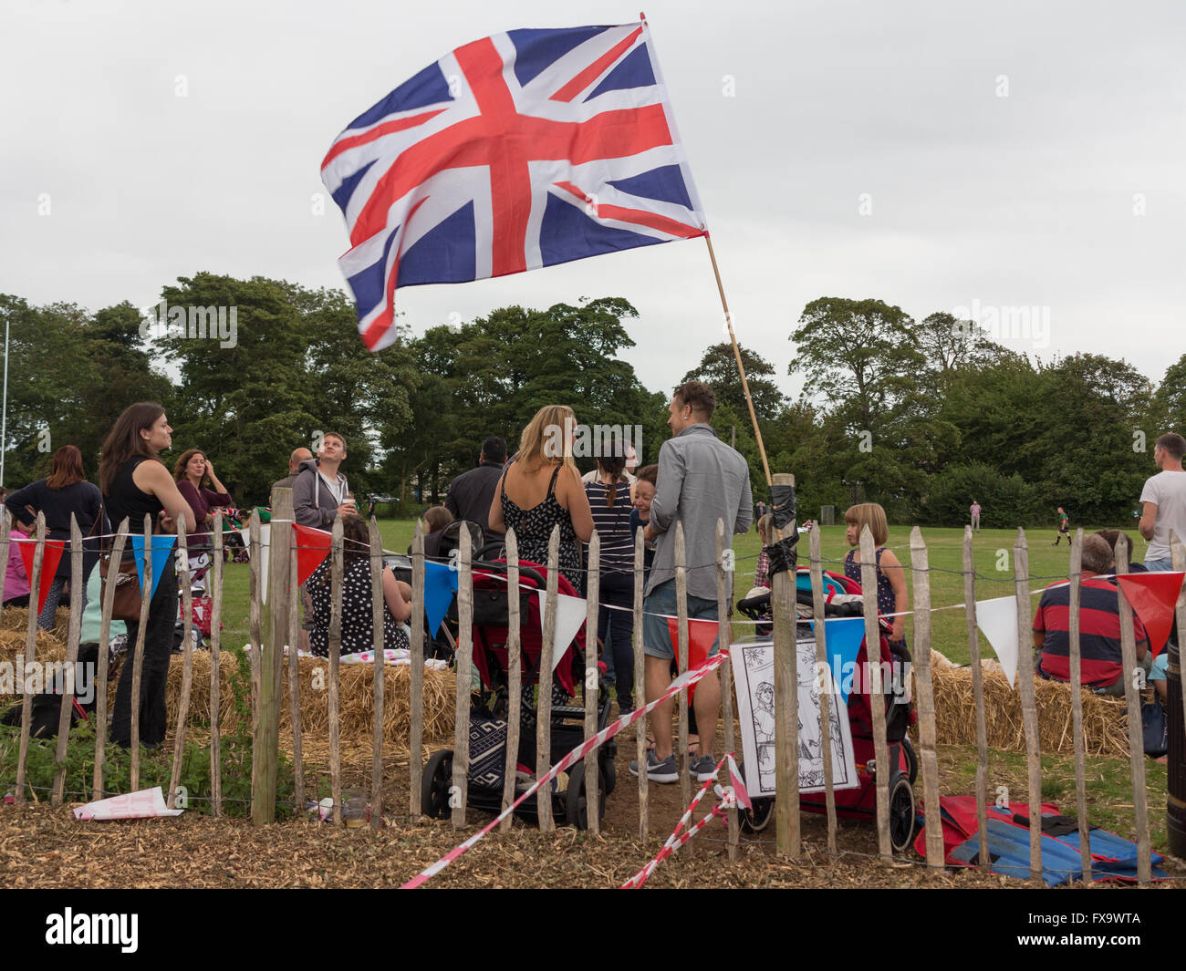 people at village fete with Union flag flying in Aldeburgh, Suffolk ...