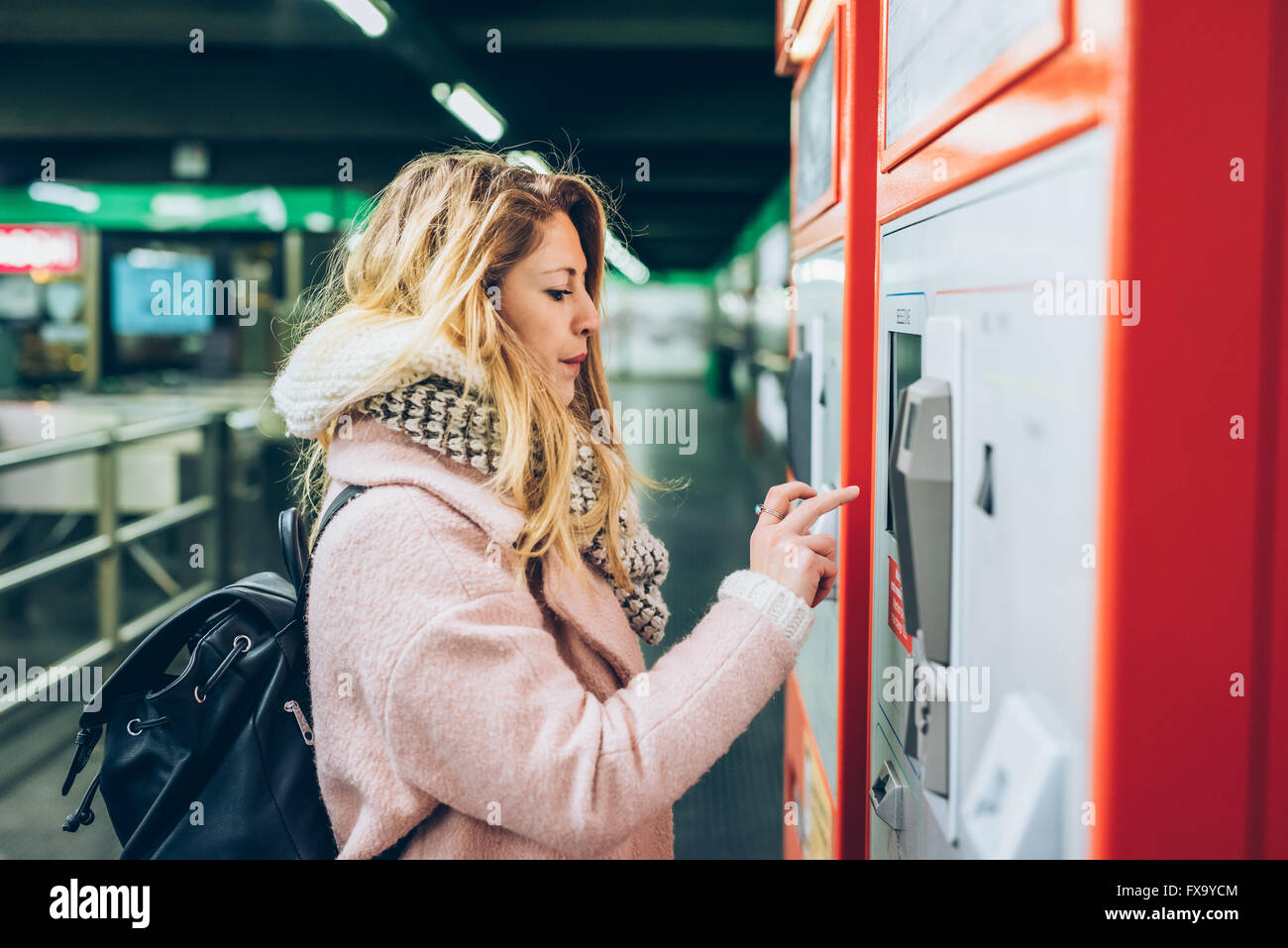Half length of young beautiful blonde caucasian woman buying a ticket ...