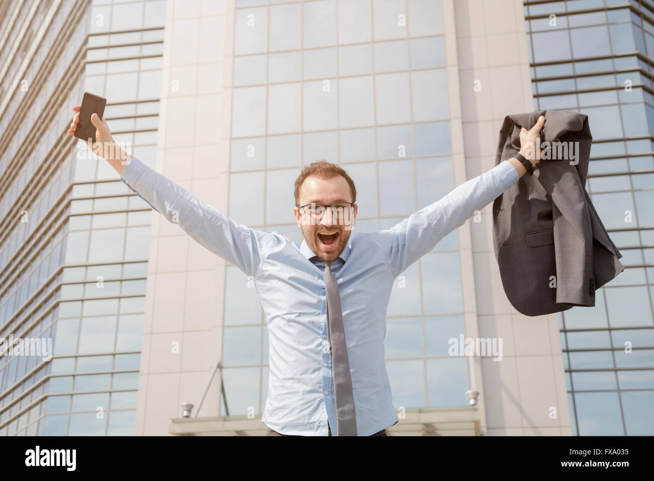 Happy businessman celebrating his success in front of the business ...