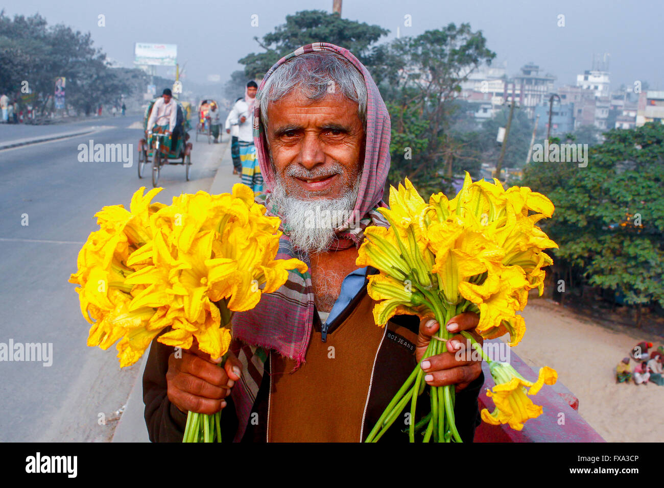 An old man selling pumpkin flowers (kumro ful) in street side of Dhaka ...