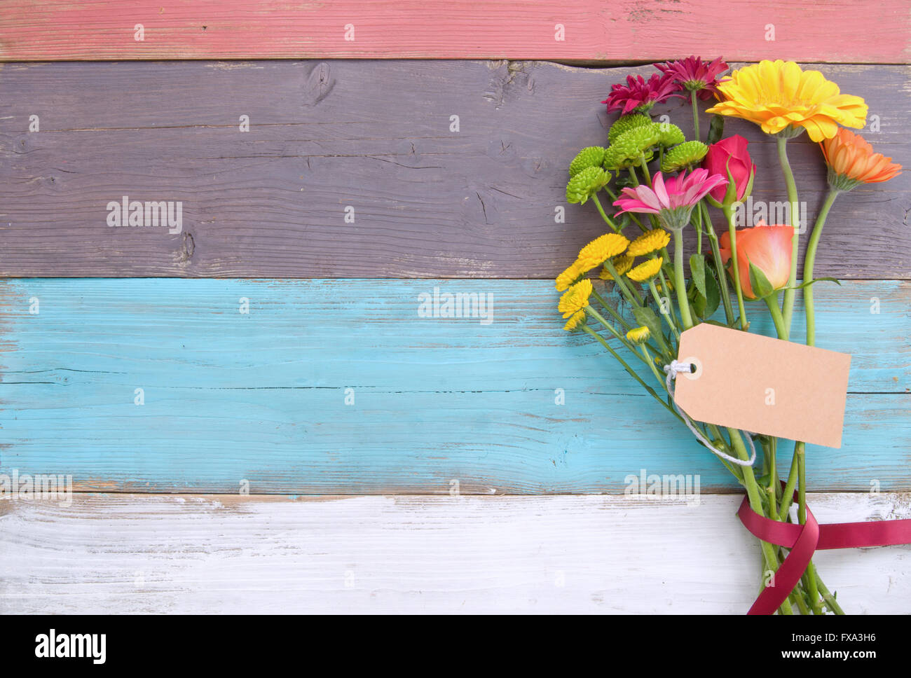 Bunch of flowers with blank gift label on wooden background Stock Photo ...
