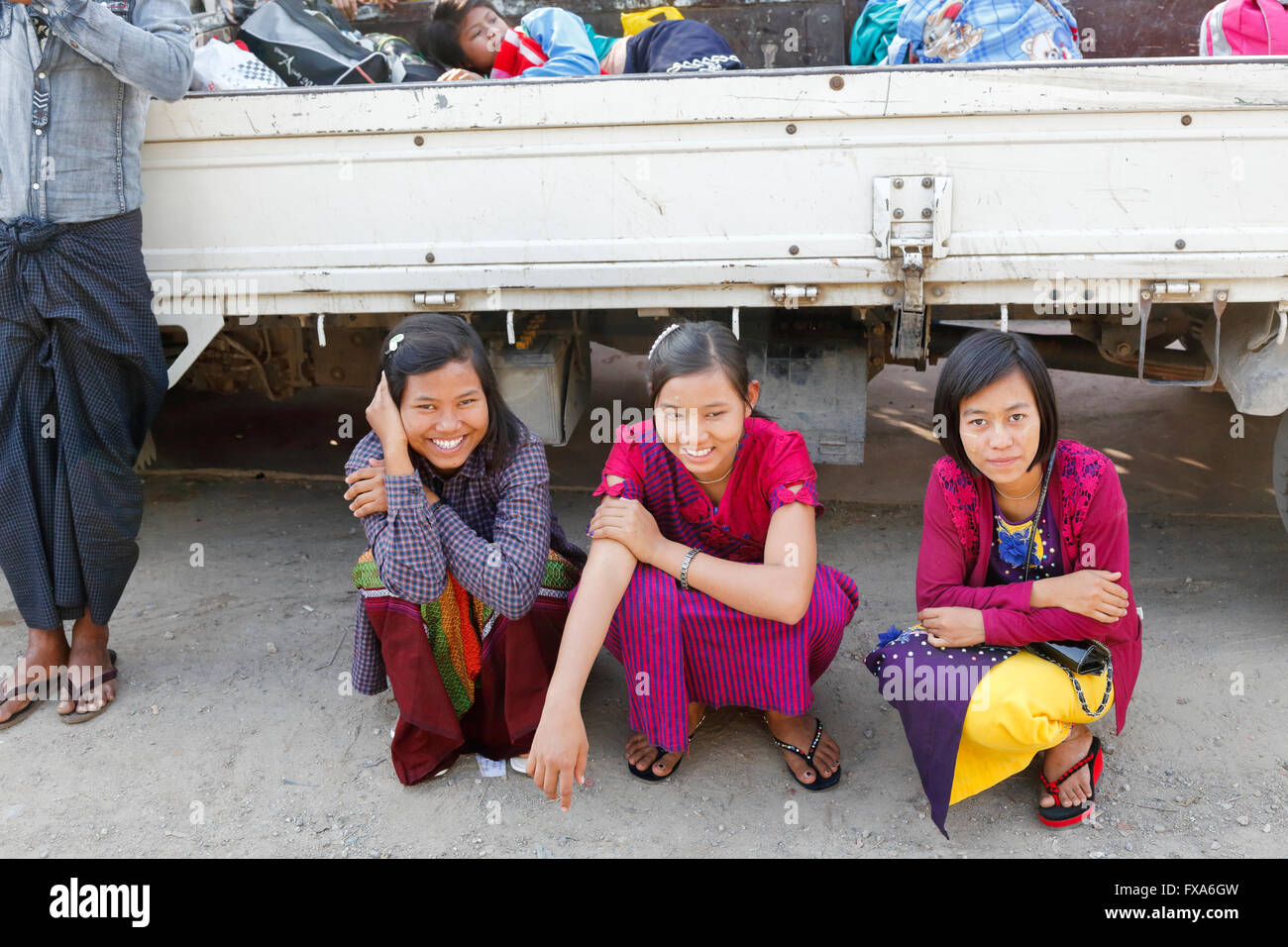 Three Smiling Young Local Girls Squatting By A Lorry At Kyauk Taw Gyi