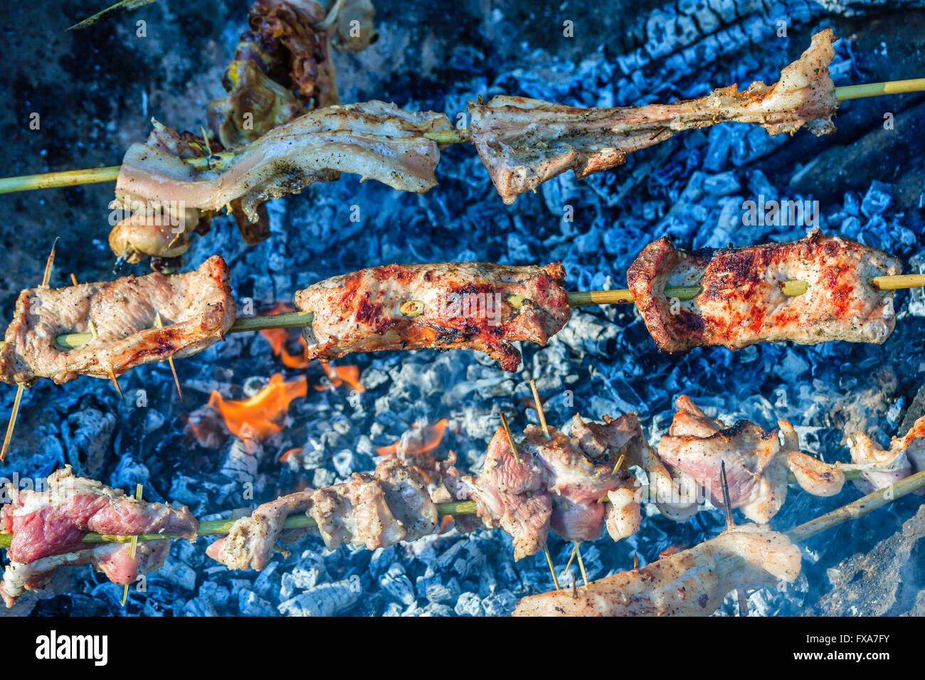 Grilling meat with barbecue stuff Stock Photo - Alamy
