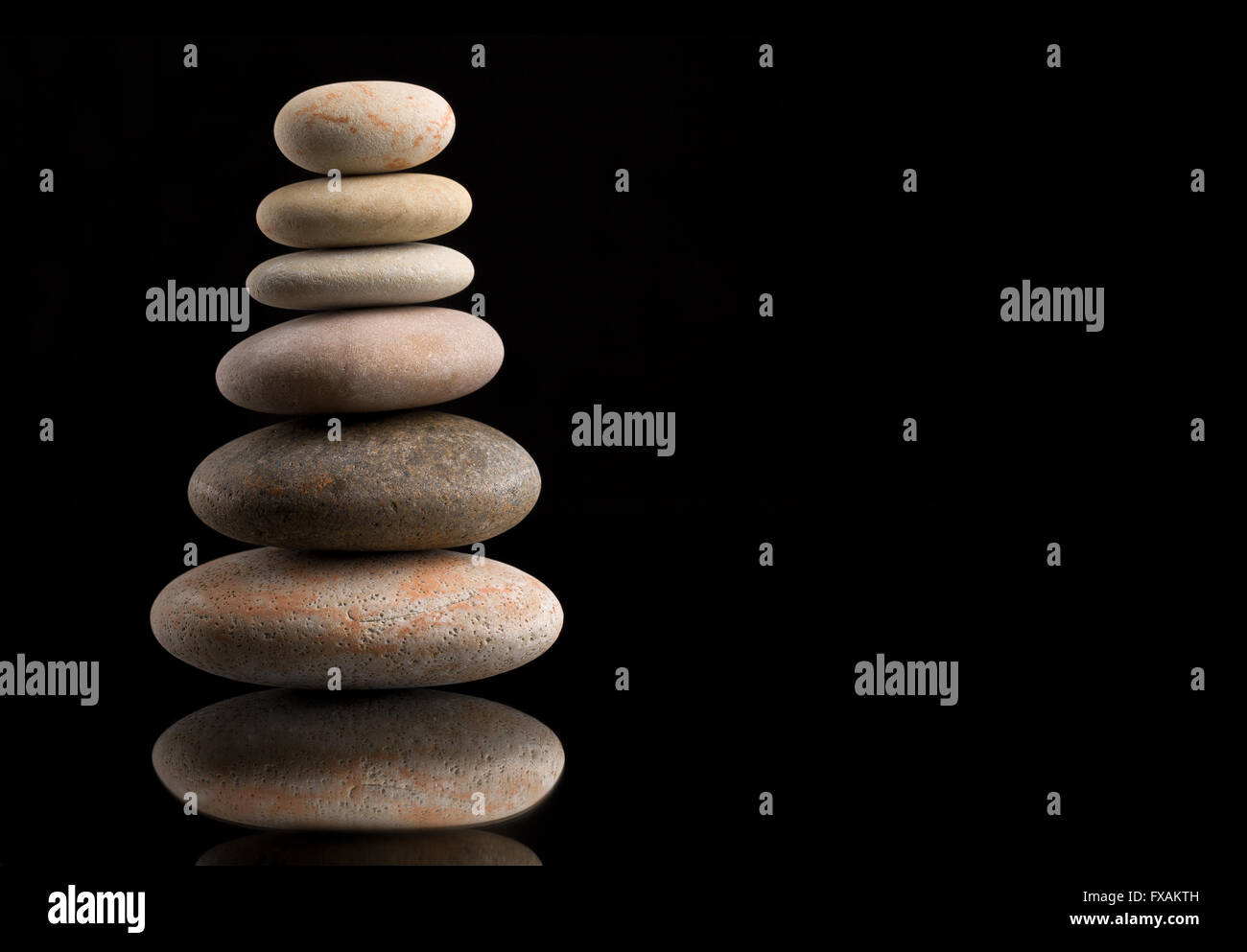 Pile of balancing pebble stones, like ZEN stone, on black background ...