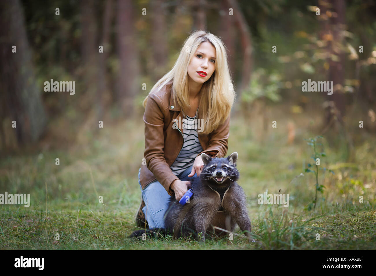 Portrait of attractive young woman with raccoon in a forest Stock Photo ...