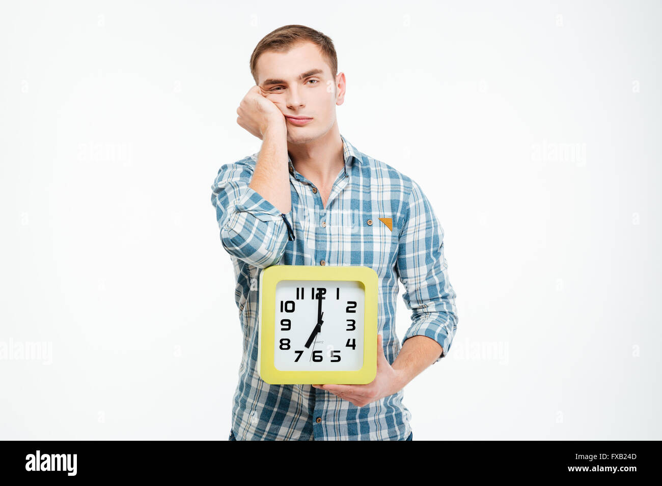 Sad bored young man holding big clock over white background Stock Photo ...